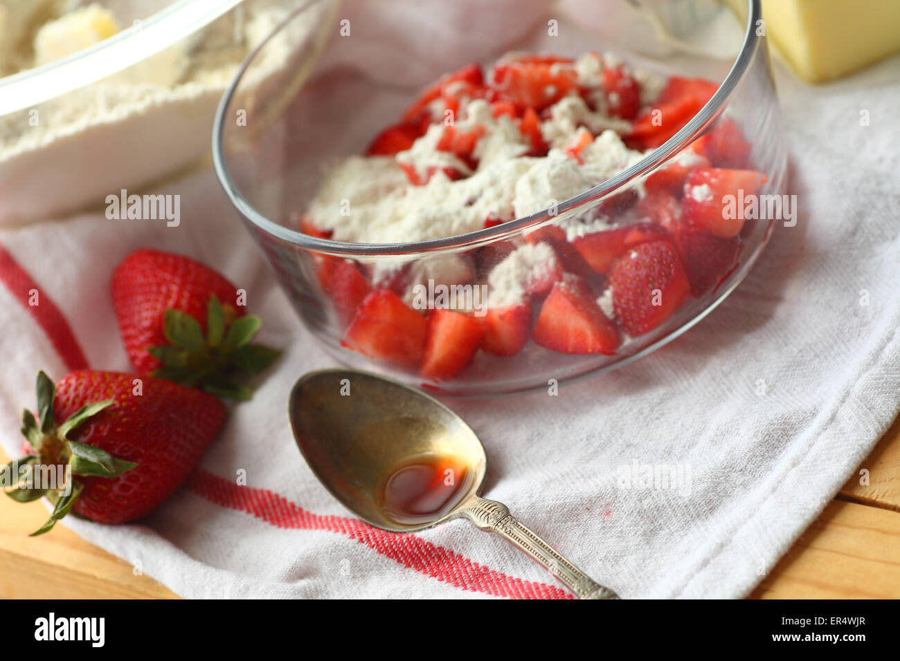 Baking still life with whole and chopped strawberries, flour, butter ...