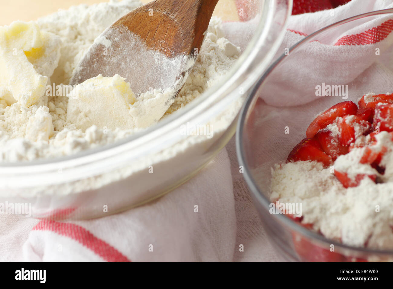 Mixing bowl with flour and butter with wooden spoon, a bowl of chopped ...