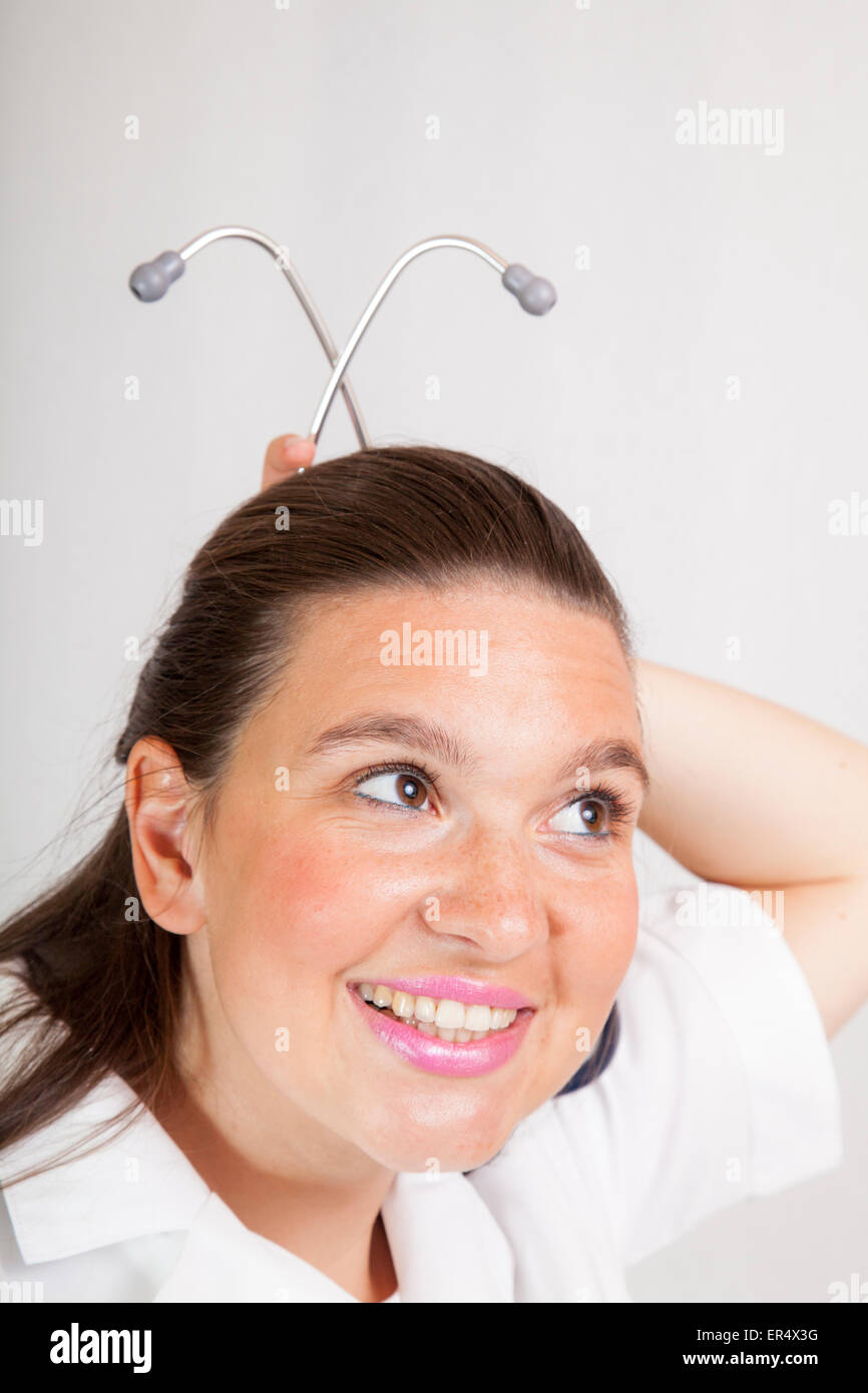 Attractive young female doctor singing to her stethoscope, space for ...