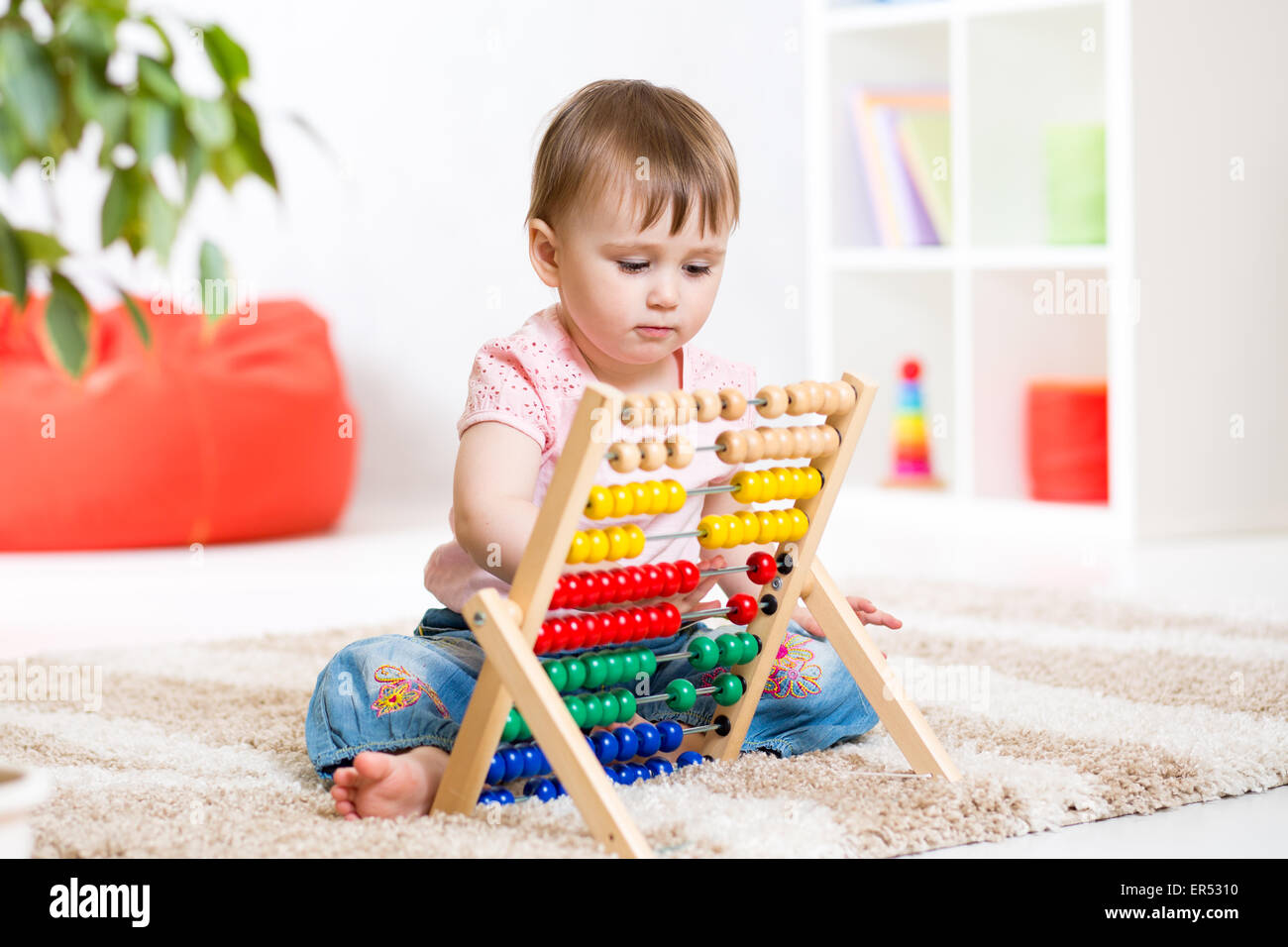 smiling child girl playing with counter toy Stock Photo - Alamy