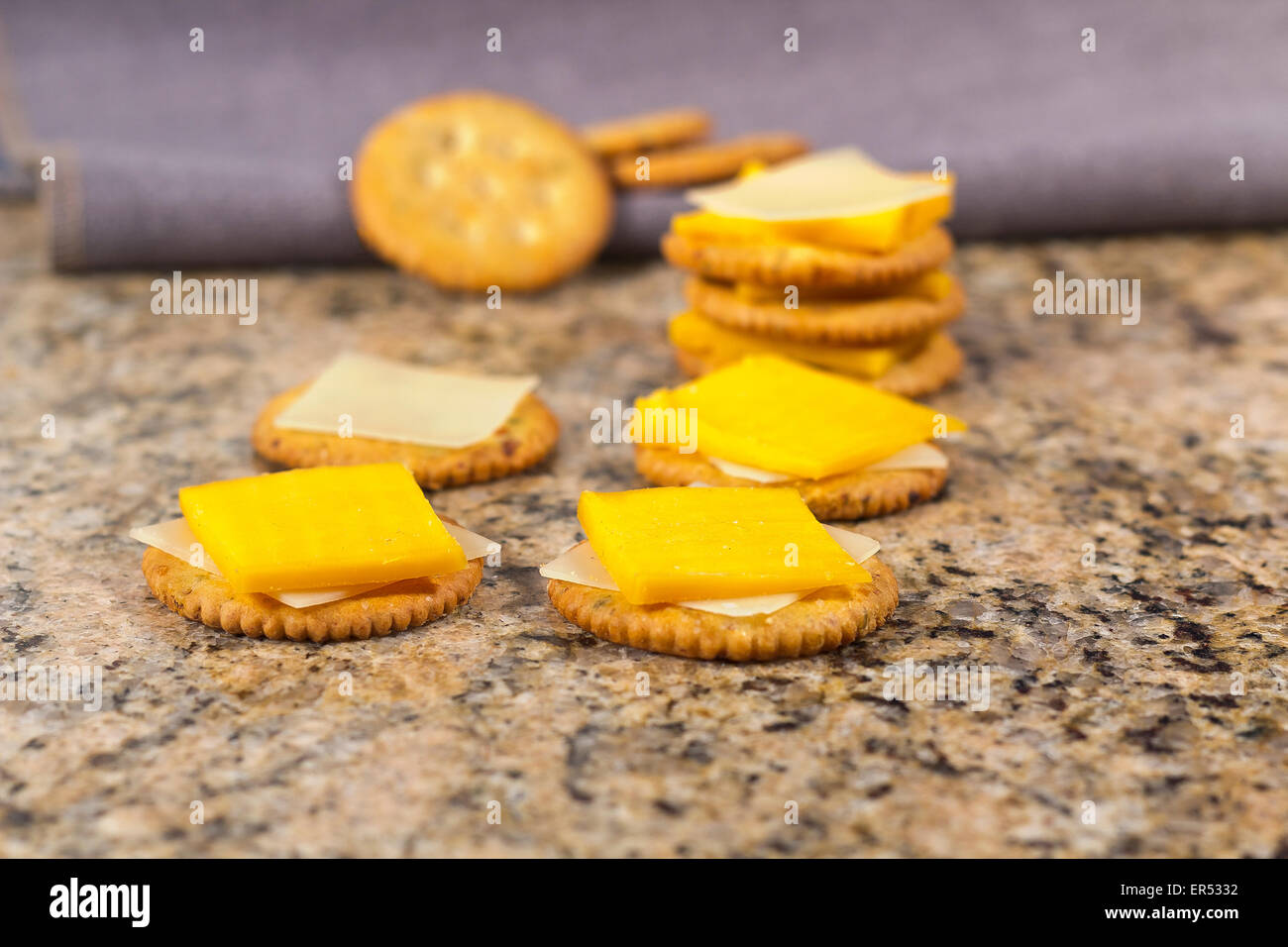 Snack of crackers and yellow and white cheddar cheese and cold milk ...