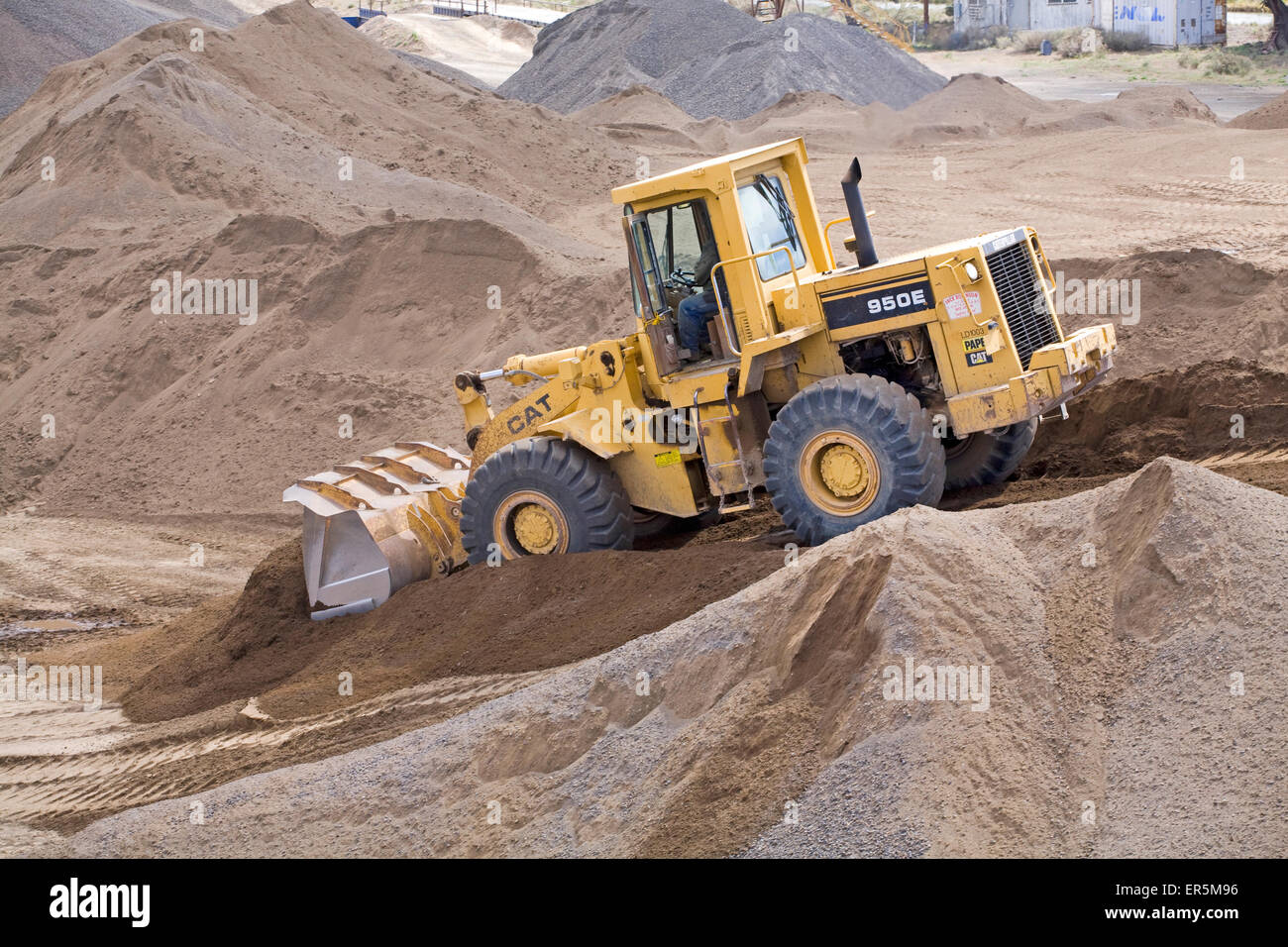 A caterpillar "cat" 950E earth mover plows into a pile of dirt at a ...