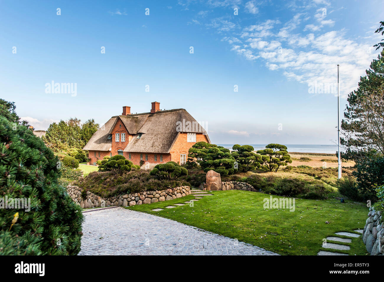 Thatched-roof house with Wadden Sea in background, Kampen, Sylt ...