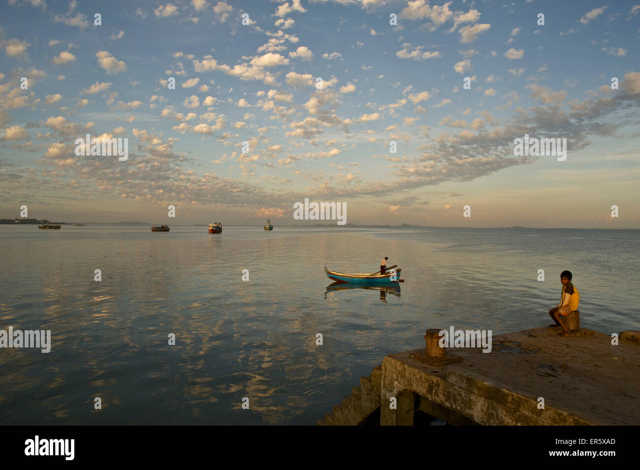 Child sitting on the the pier, Sittwe, Akyab, fishing boat with some ...