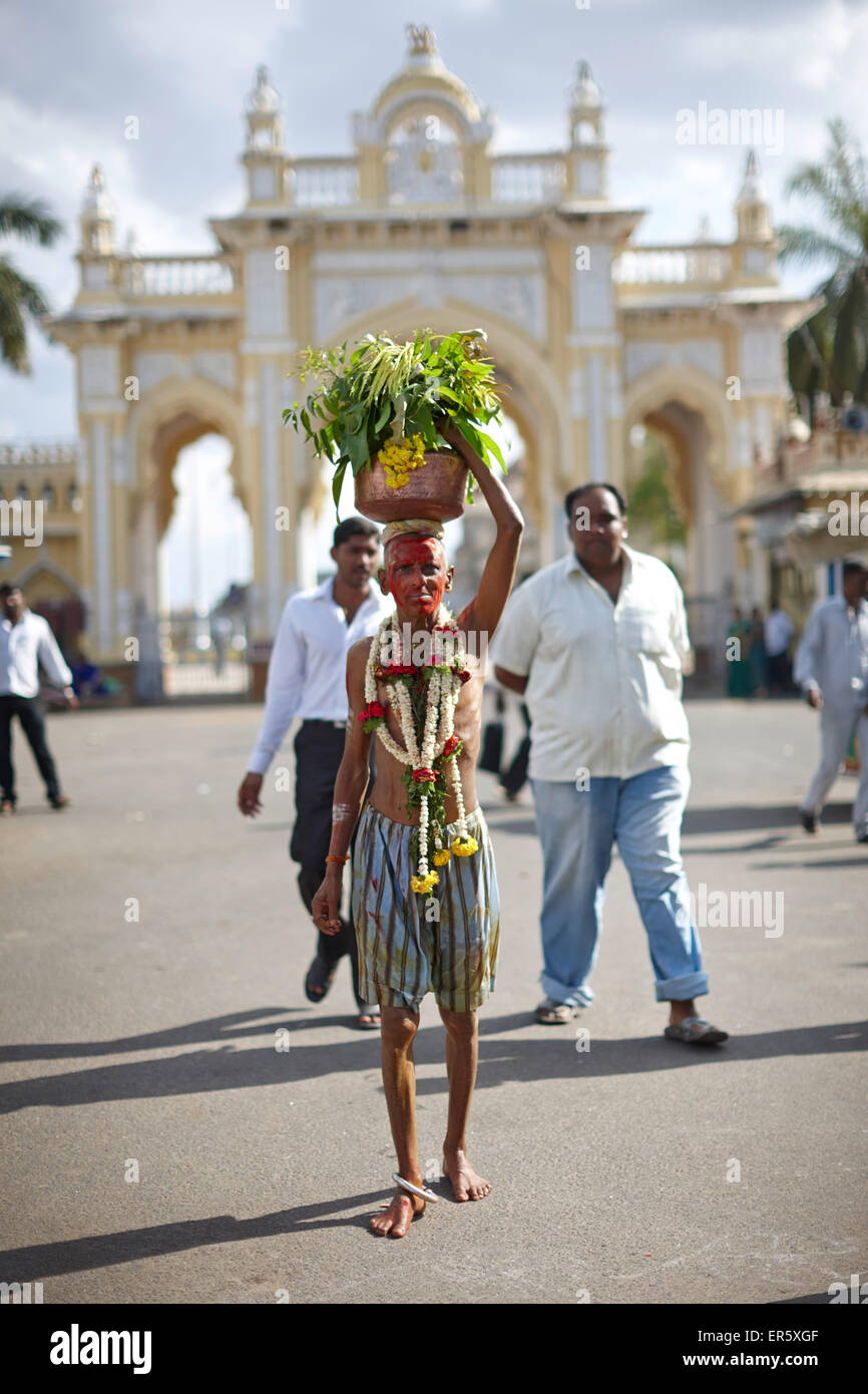 Pilgrim carrying holy water, gate to Amba Vilas Palace in background ...