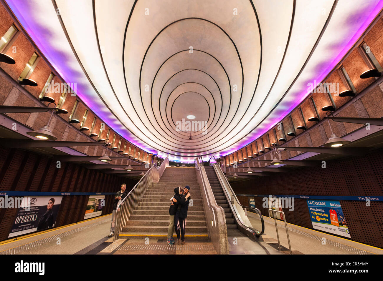 Couple embrace under the giant illuminated ceiling of the Plac Wilsona ...
