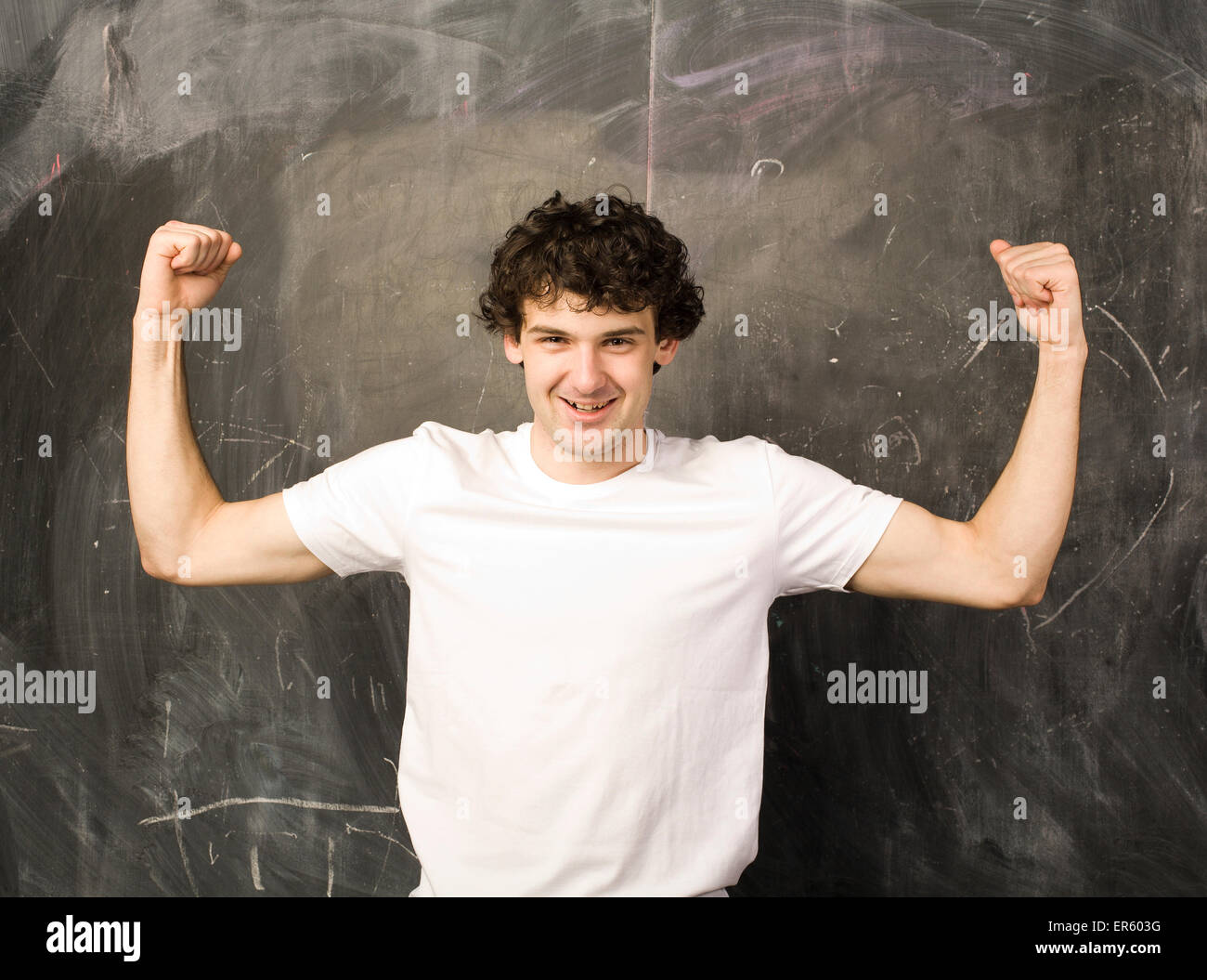 Handsome man casually learning against the blackboard, victory t Stock ...