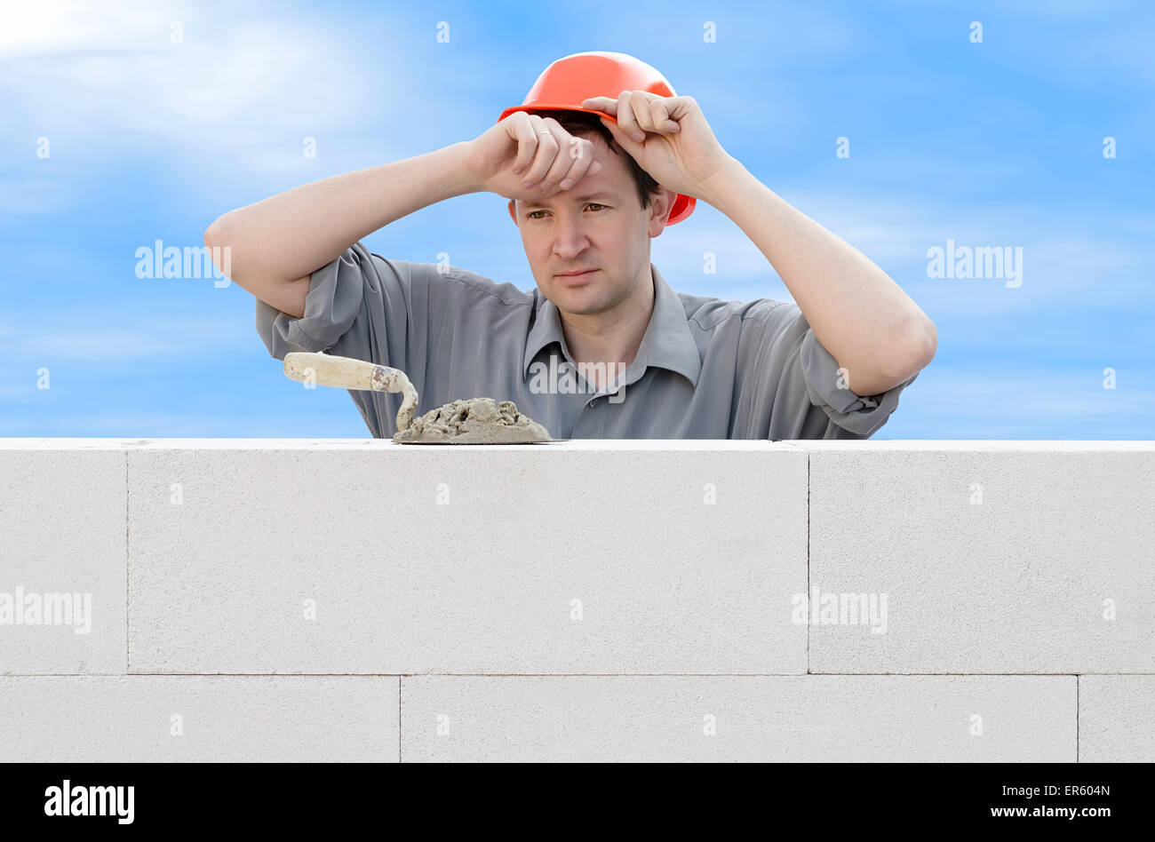 Construction worker wiping the sweat from his forehead Stock Photo - Alamy