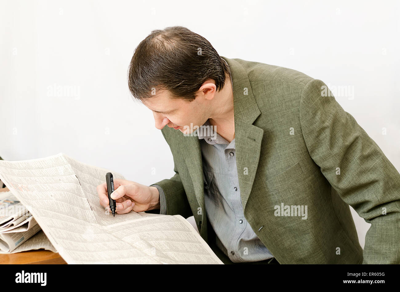 the man reads the newspaper behind a desktop Stock Photo - Alamy
