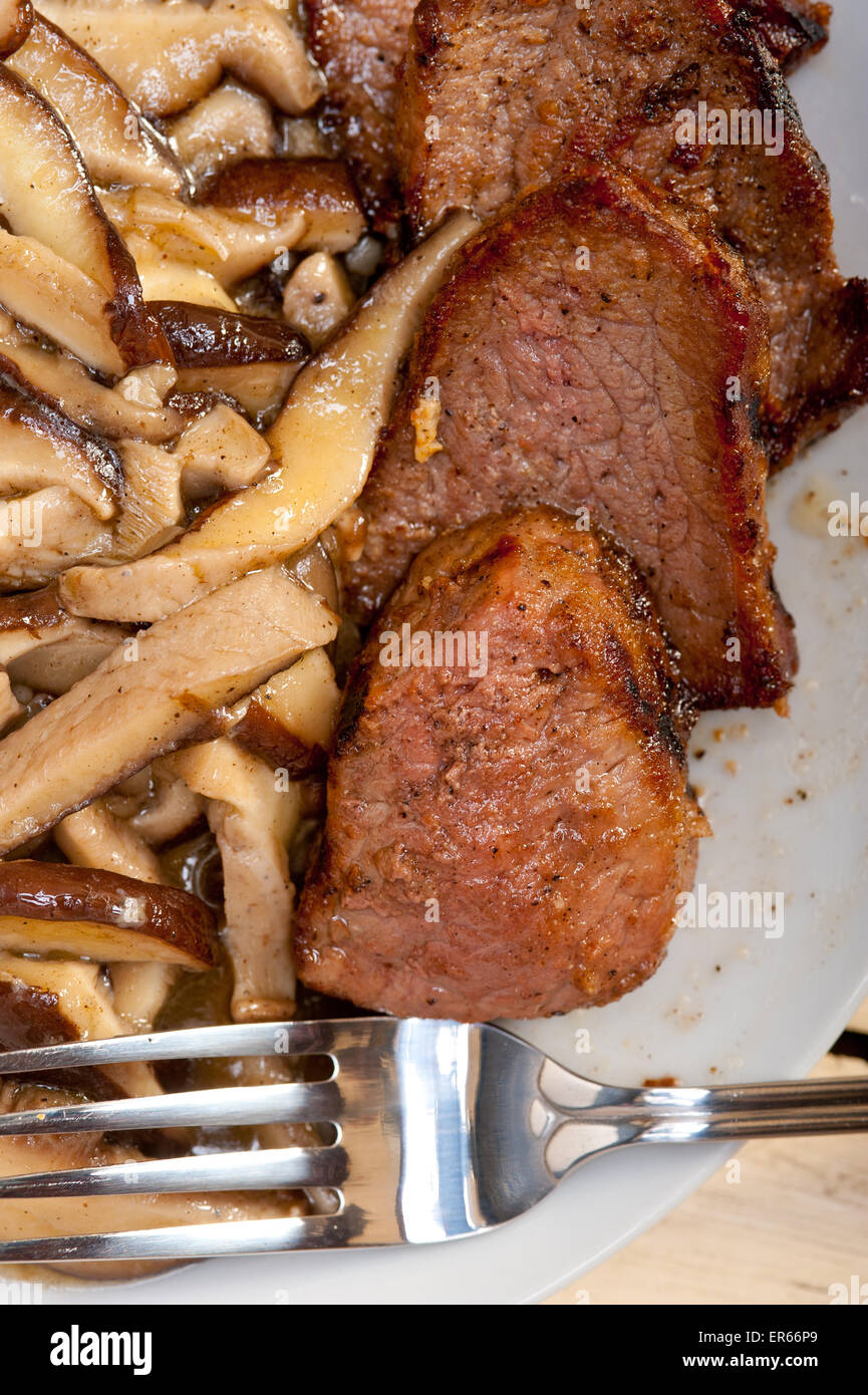 venison deer game filet tenderloin and fresh wild mushrooms Stock Photo ...