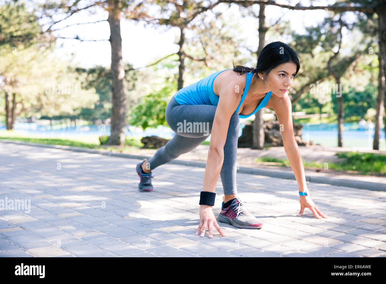 Fitness woman runner in start position outdoor Stock Photo - Alamy