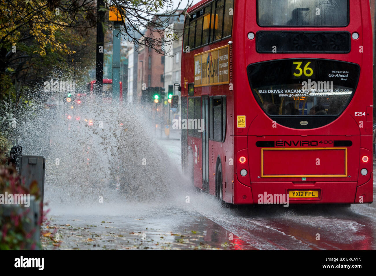 A London bus drives through a large puddle on London's Vauxhall Bridge ...