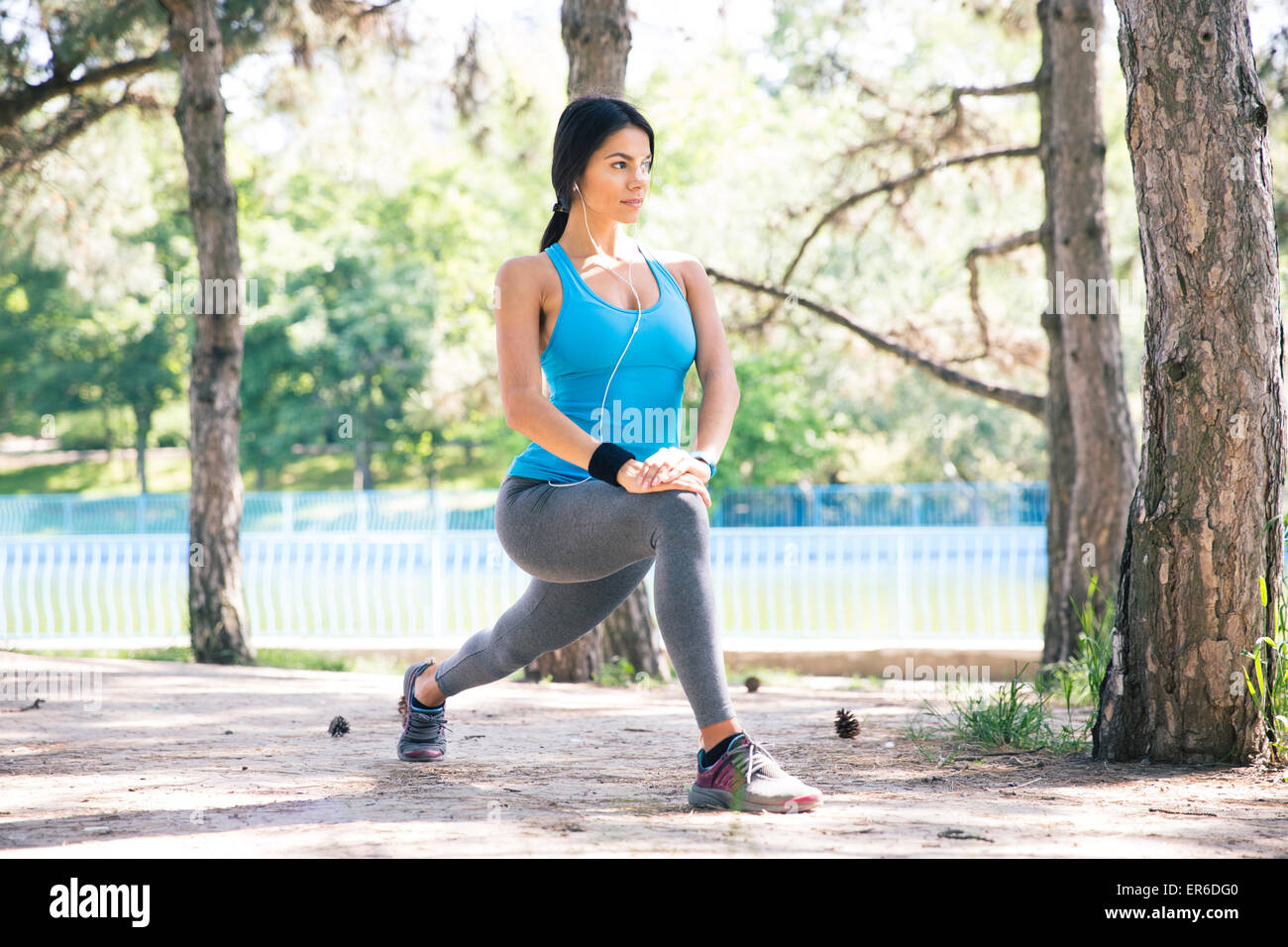Fitness woman doing stretching exercise outdoors in park Stock Photo - Alamy