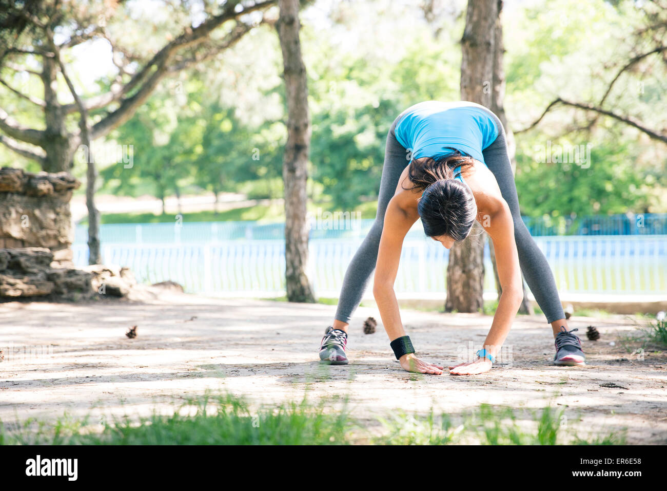 Sporty woman doing stretching exercise outdoors in park Stock Photo - Alamy