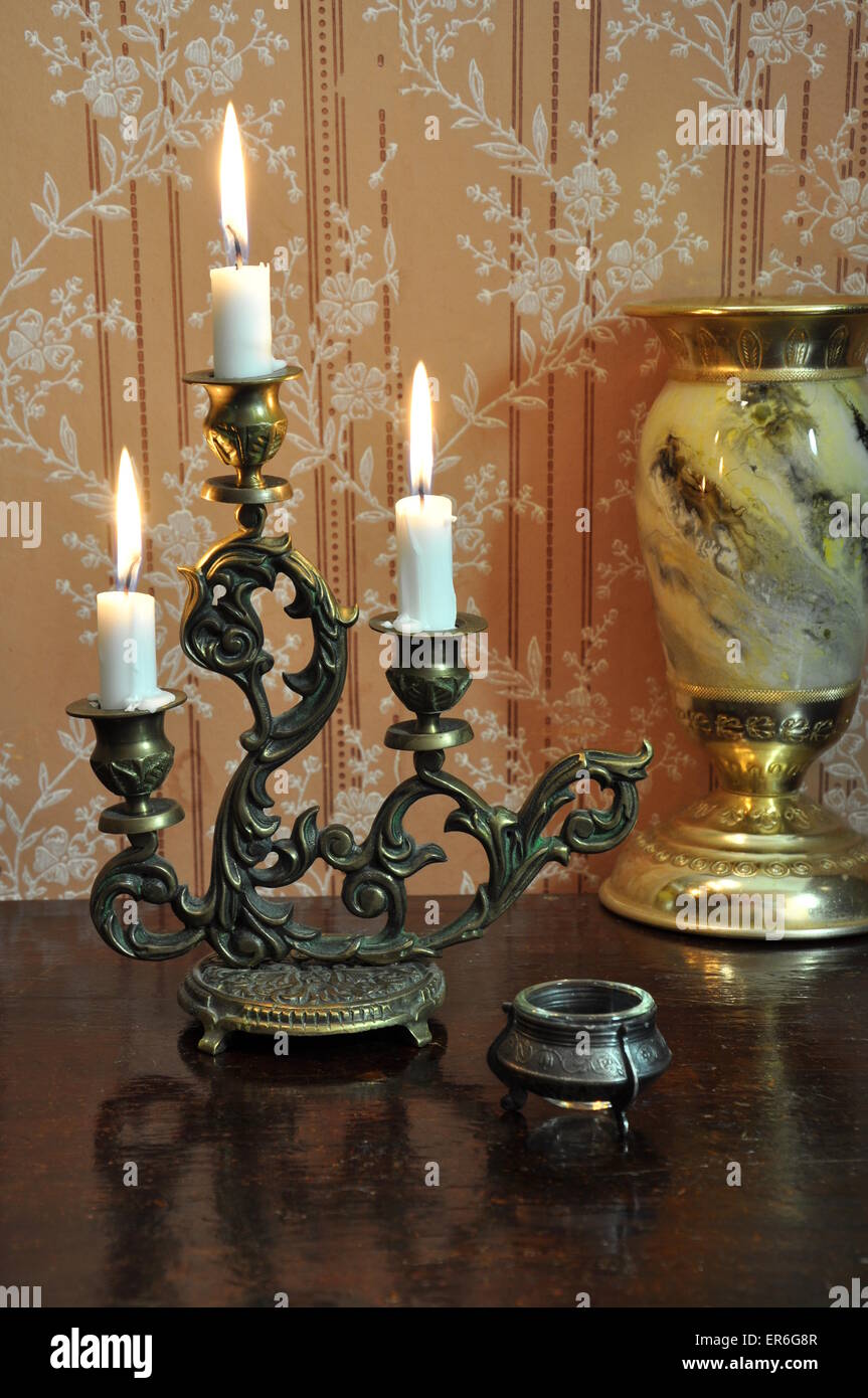 Elegant still life with ornate bronze candelabra and antique goblet on ...