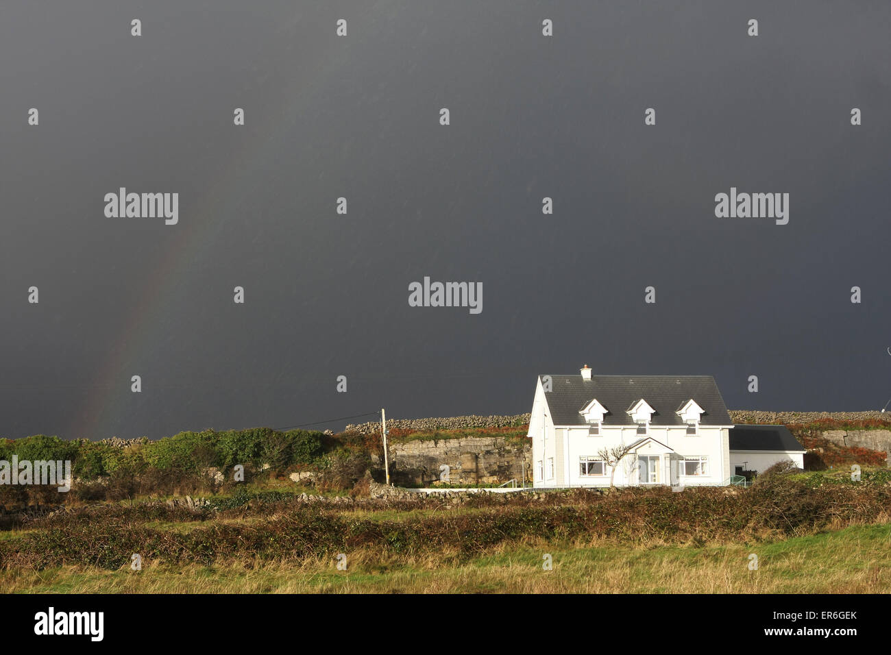typical Irish cottage during a rainstorm with rainbow.Inishmore,Aran ...