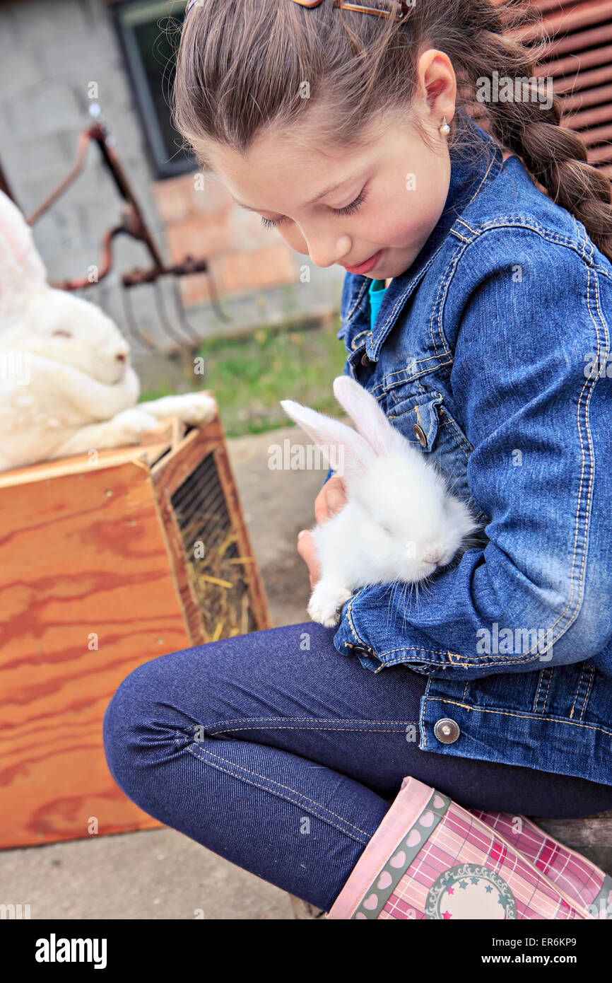 little girl with a rabbit in front of the farm Stock Photo - Alamy