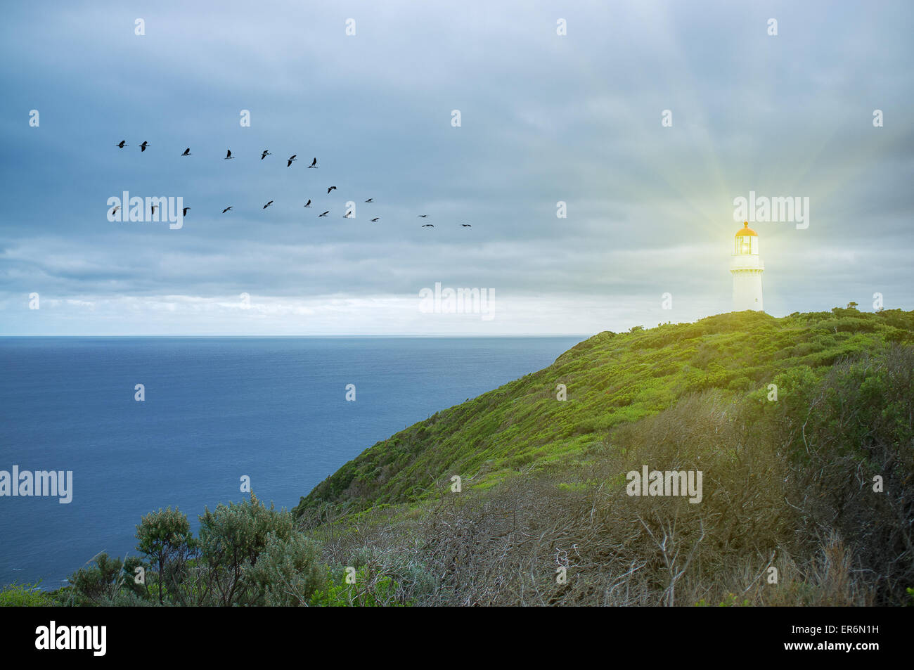 Lighthouse shining protective light over ocean Stock Photo - Alamy