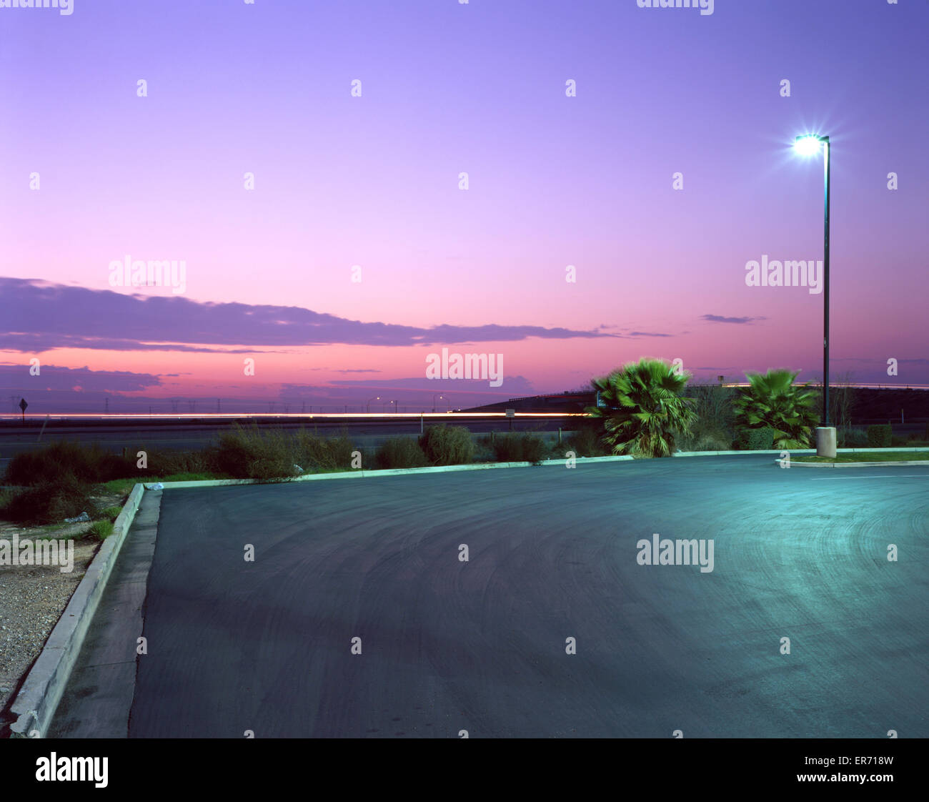 Highway and parking lot at sunset Stock Photo - Alamy