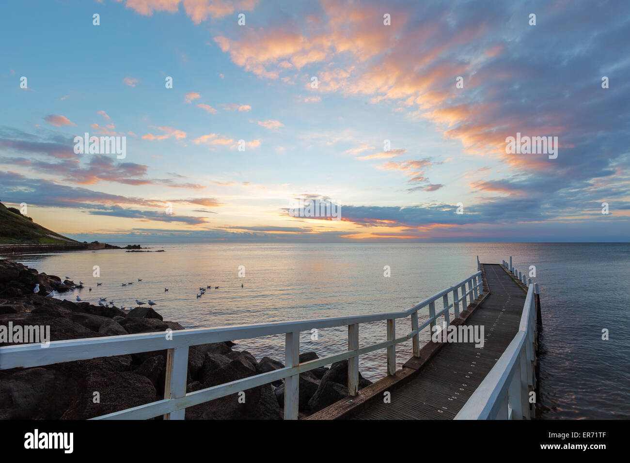 Small Jetty leading into the sunset Stock Photo - Alamy