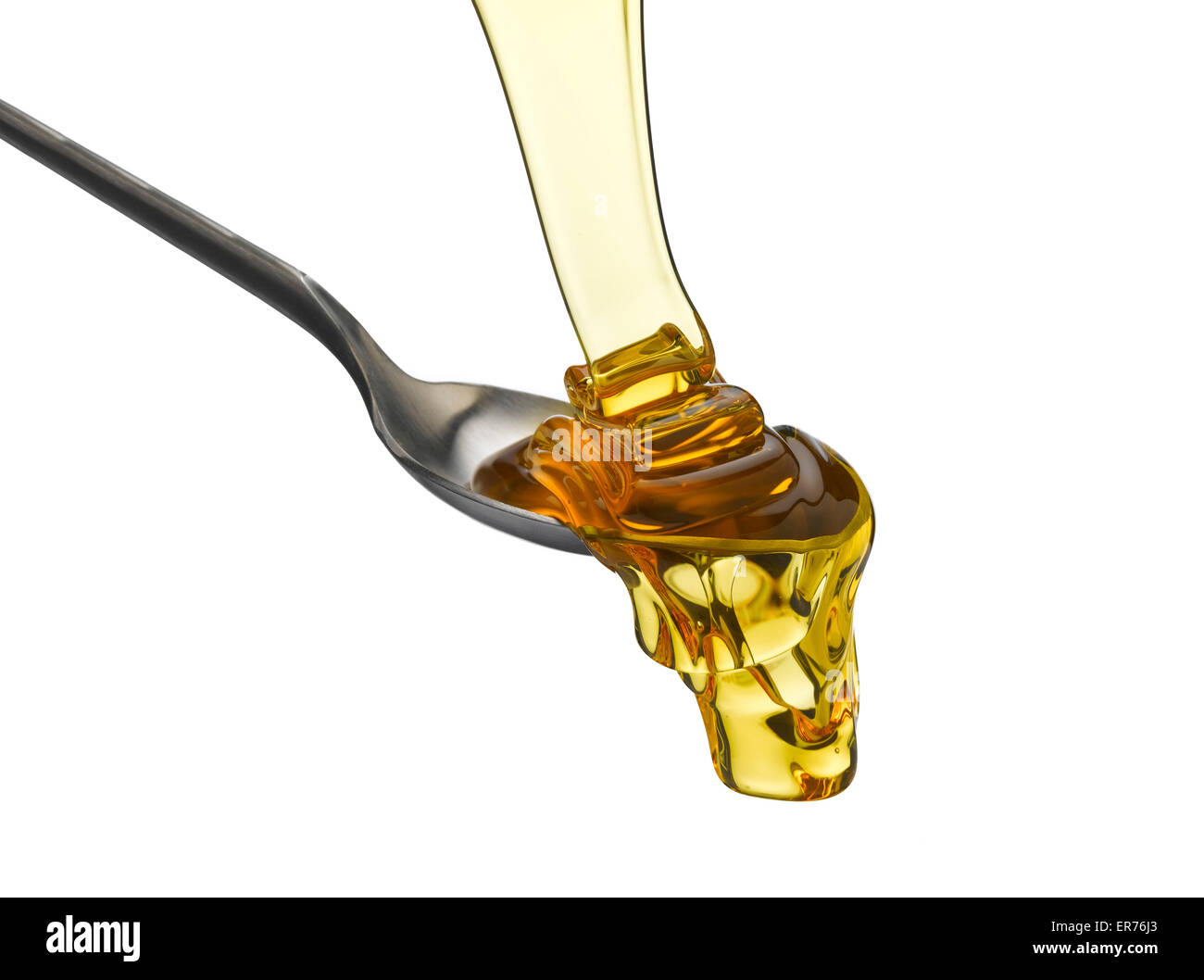 Treacle flowing onto a spoon Stock Photo - Alamy