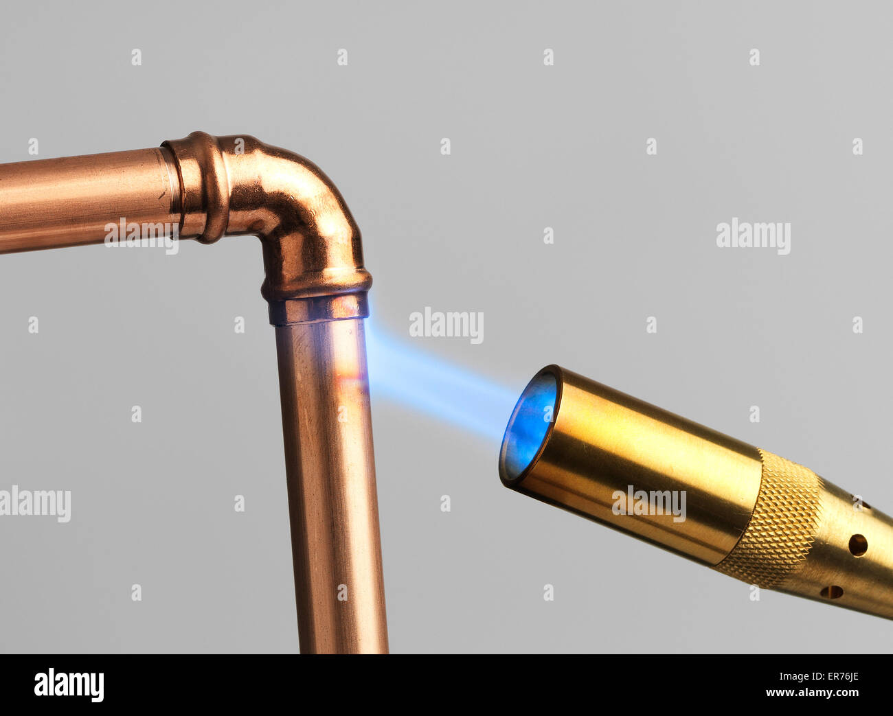 Blowtorch with flame on gray Stock Photo - Alamy