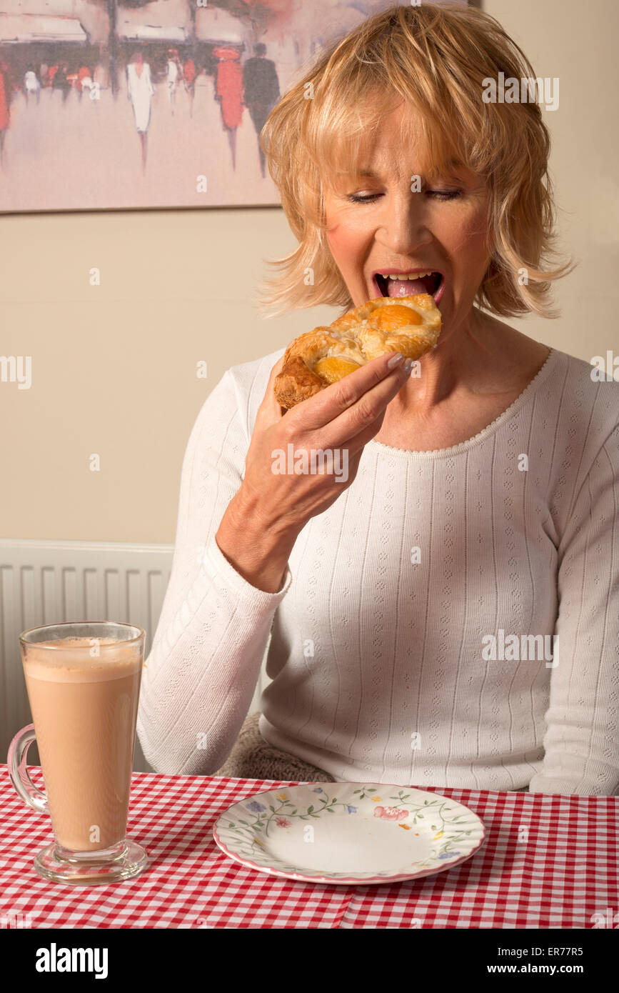 Woman at home eating a Danish pastry Stock Photo - Alamy