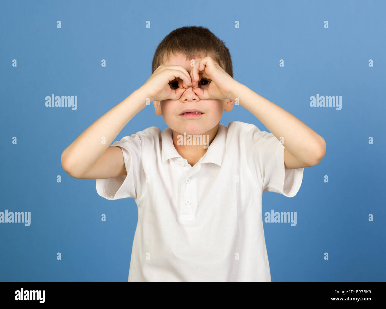 boy portrait in white shirt on blue background Stock Photo - Alamy