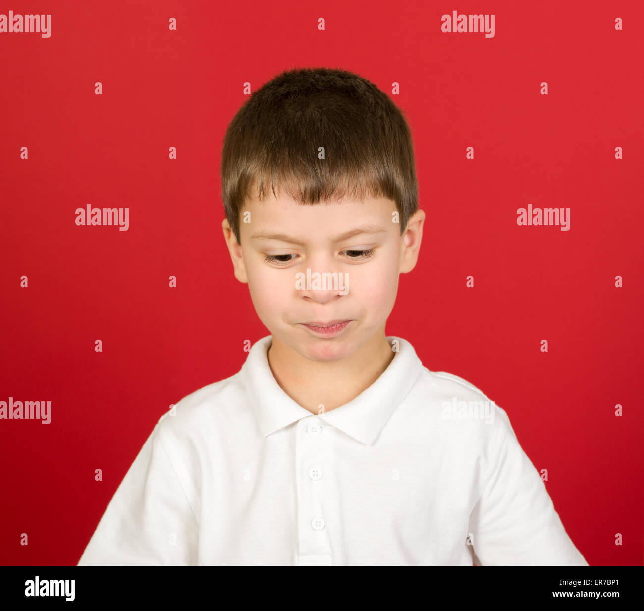 grimacing boy portrait on red background Stock Photo - Alamy
