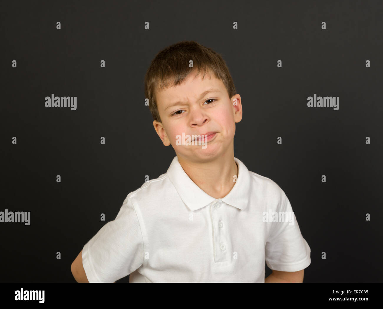grimacing boy portrait on black background Stock Photo - Alamy