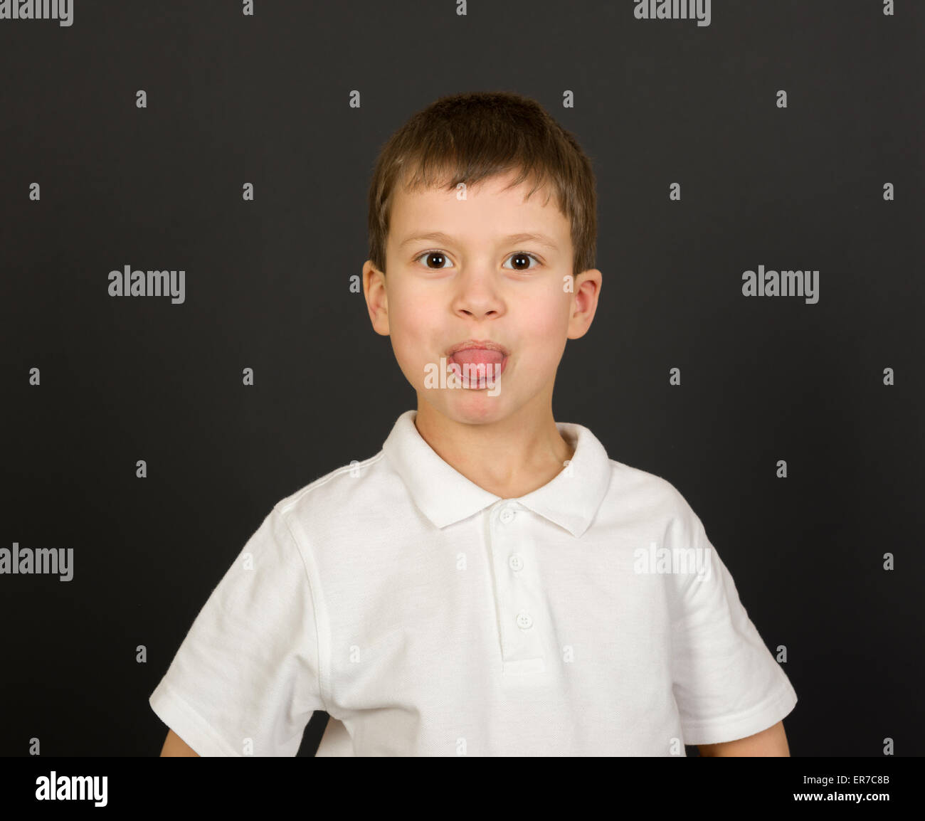 grimacing boy portrait on black background Stock Photo - Alamy