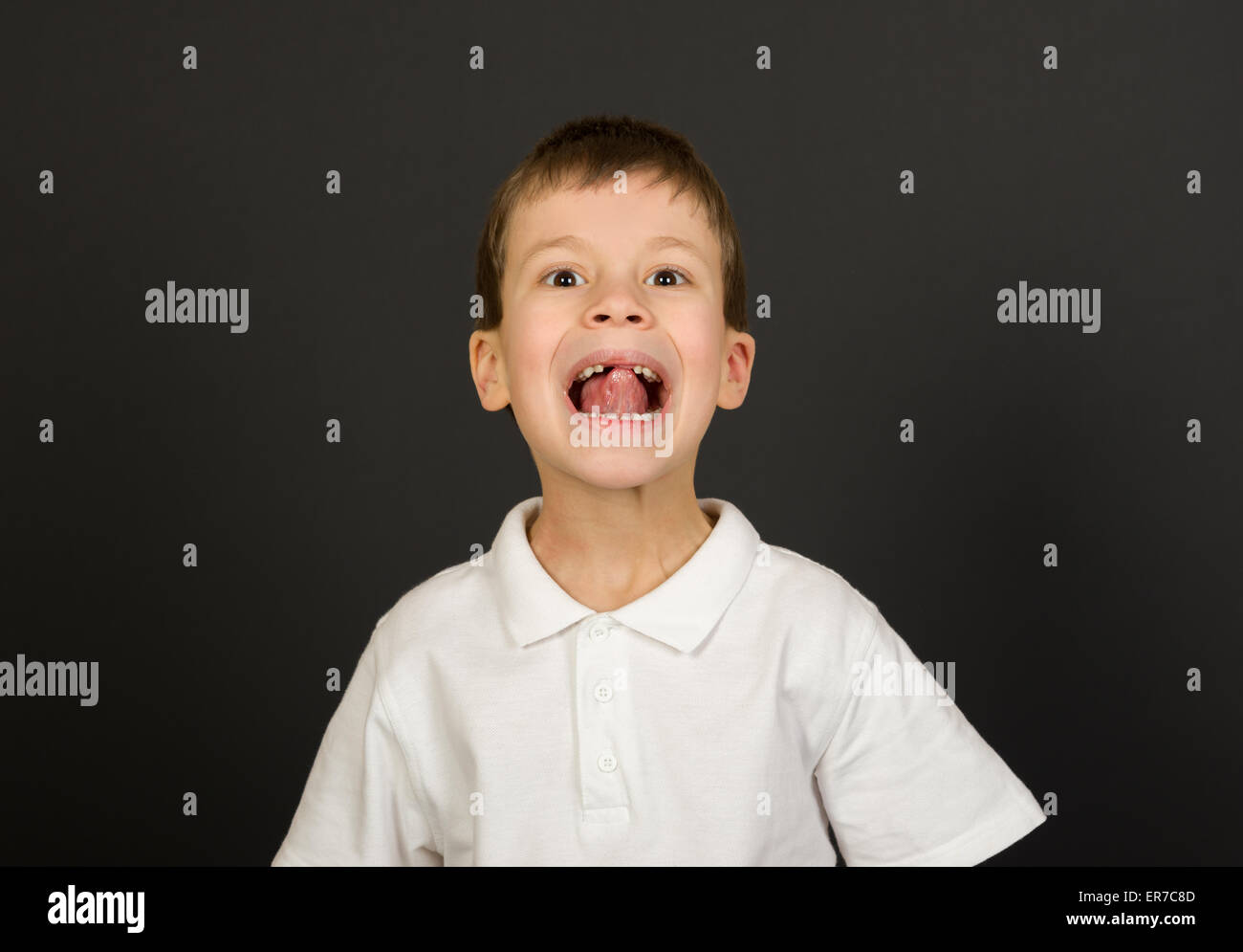 grimacing boy portrait on black background Stock Photo - Alamy