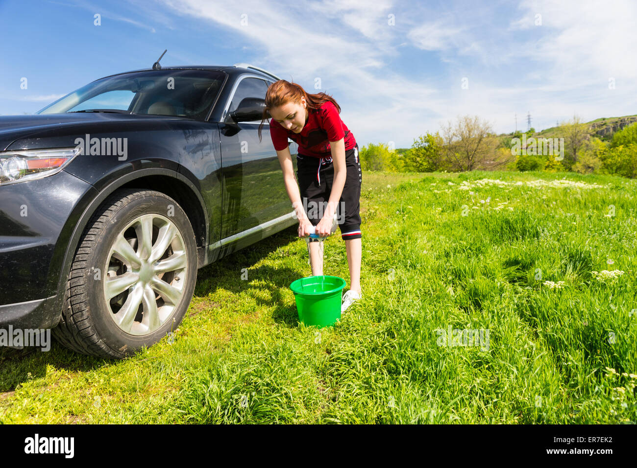 Woman with Green Bucket Wringing Out Soapy Sponge and Washing Black ...
