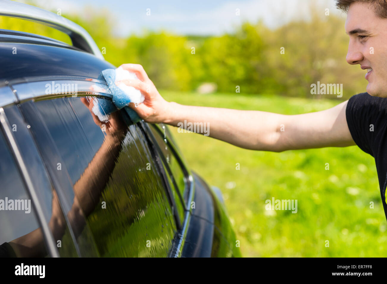 Close Up of Young Man Washing Windows of Black Luxury Vehicle with ...