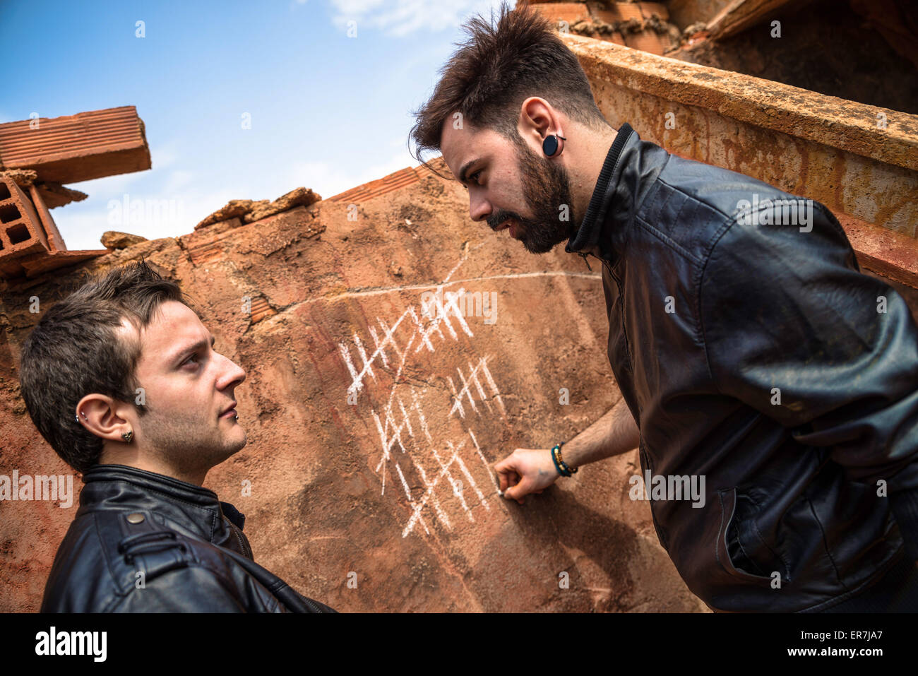Two guys counting days with chalk markings on a wall Stock Photo - Alamy