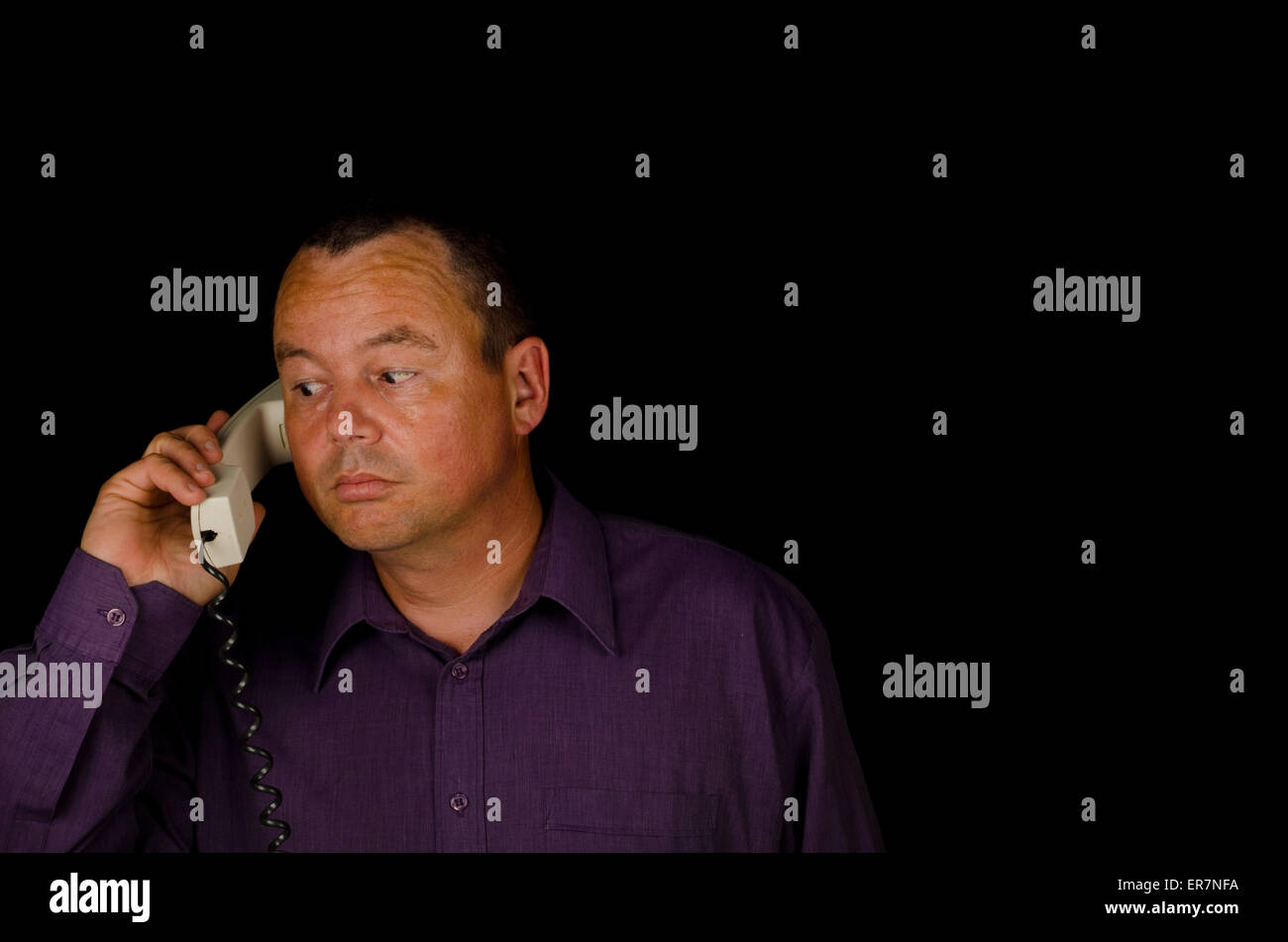Man with an incredulous expression while holding a handset Stock Photo ...