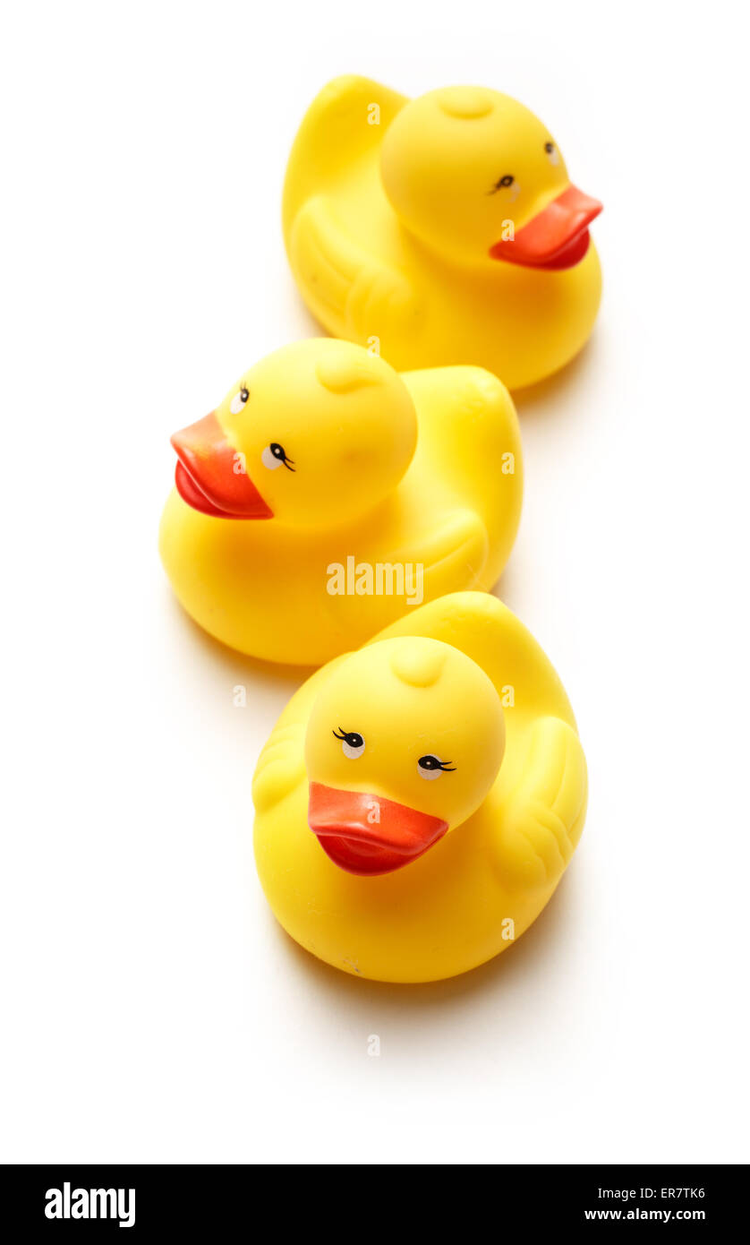 Three yellow duck toys on white background Stock Photo - Alamy