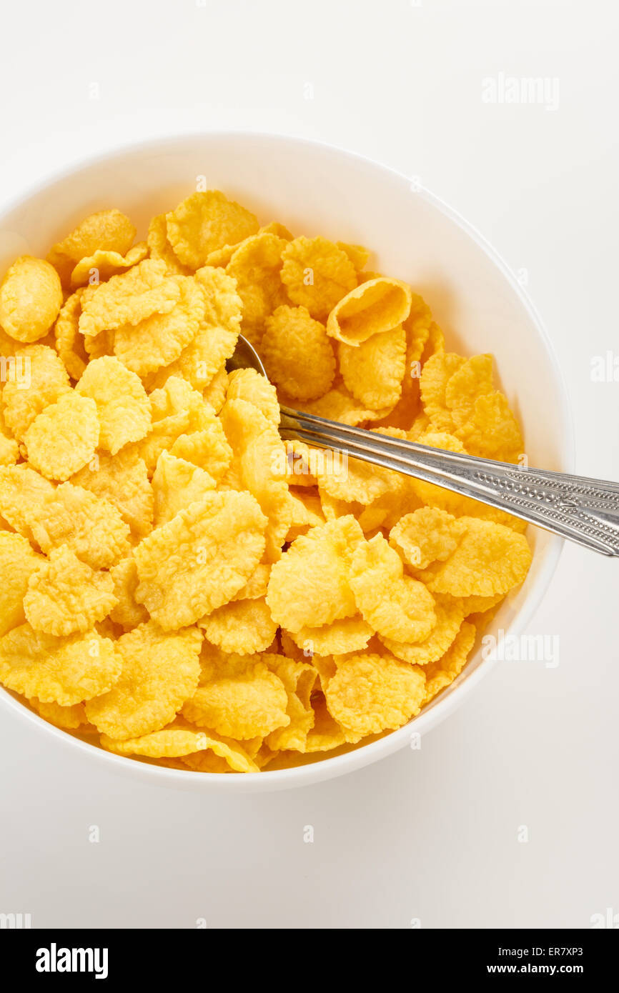 Yellow corn flakes in white bowl with spoon Stock Photo - Alamy