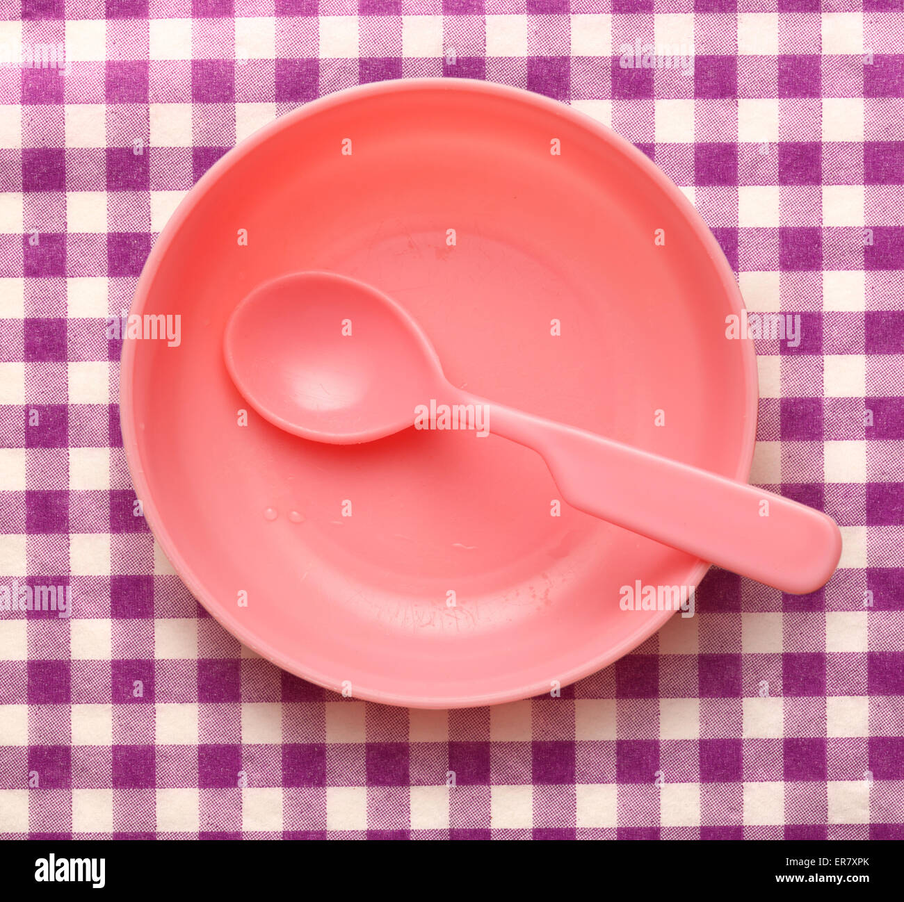 Pink plastic tableware dish, spoon and fork Stock Photo - Alamy