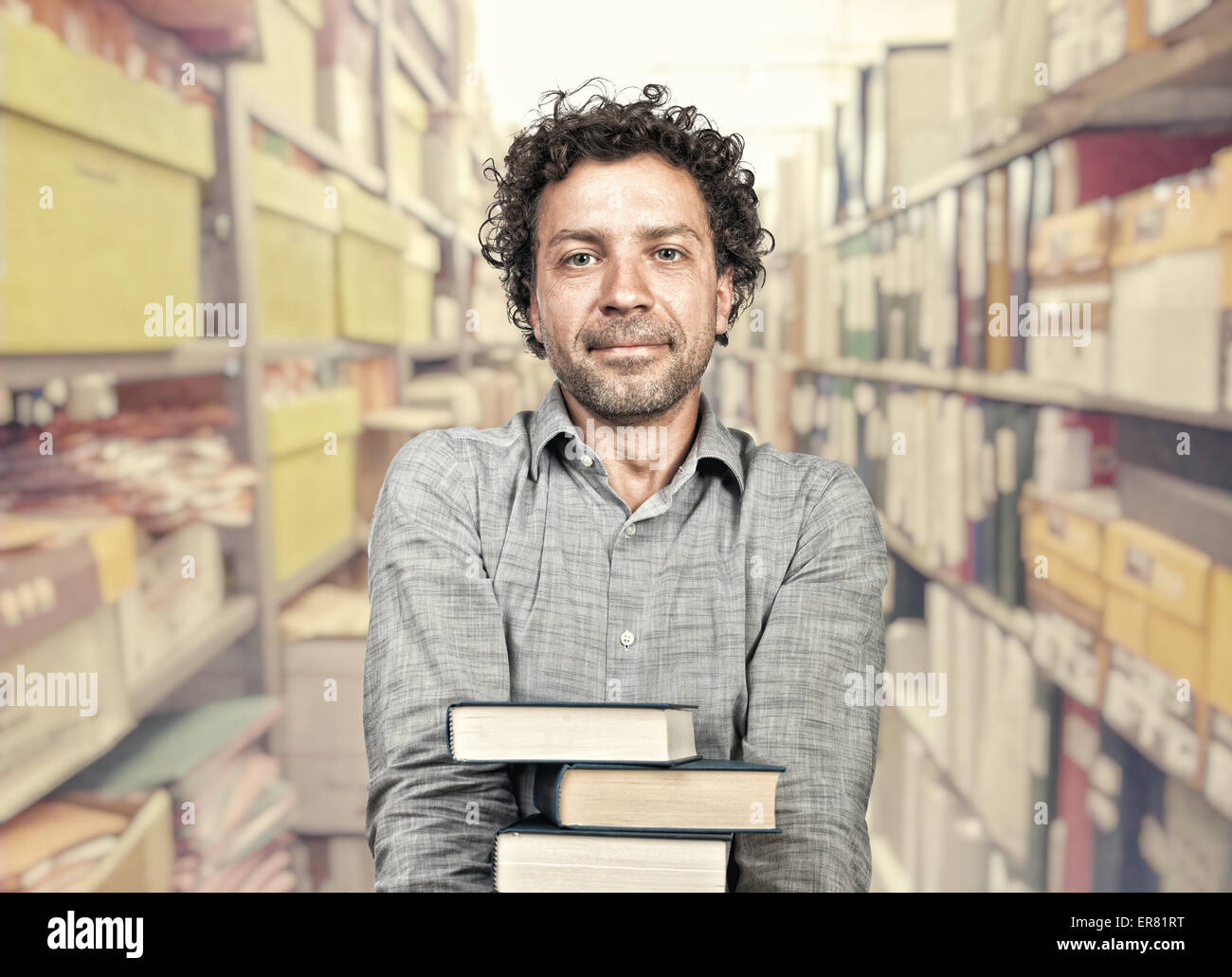 man with books in library Stock Photo - Alamy
