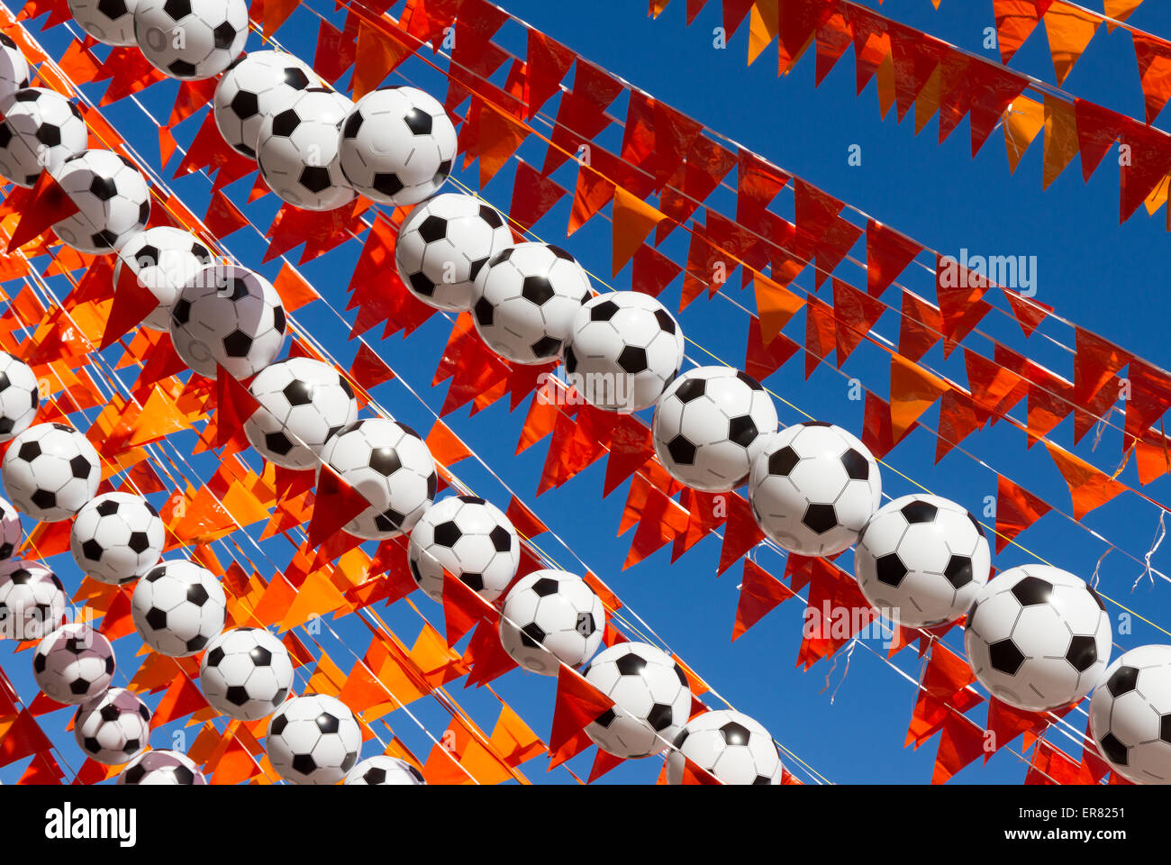 Orange flags (Dutch national color) and footballs against a clear, blue ...