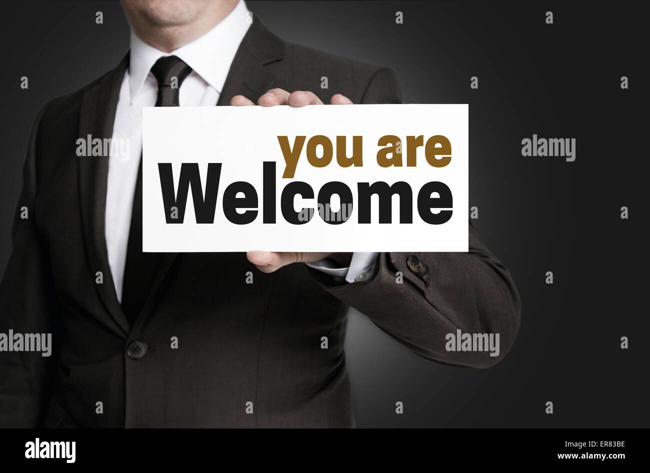 Welcome sign is held by businessman Stock Photo - Alamy
