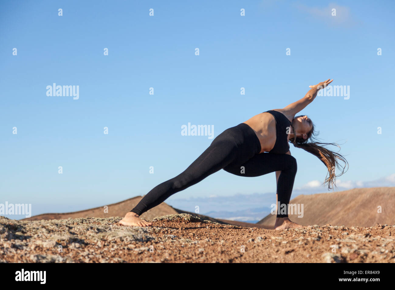 Girl doing yoga on the top of a volcano in Fuerteventura, Canary ...
