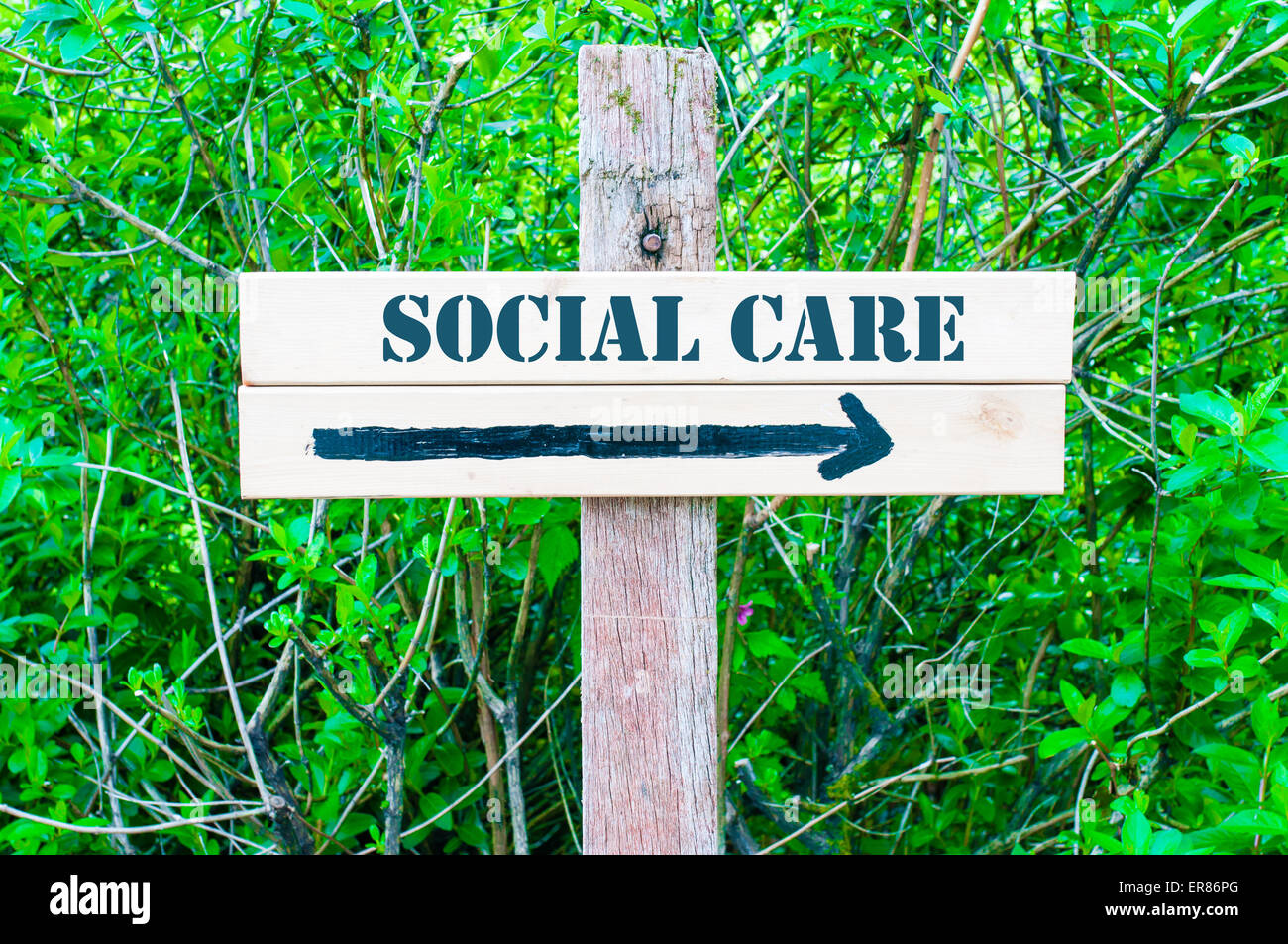 SOCIAL CARE written on Directional wooden sign with arrow pointing to ...