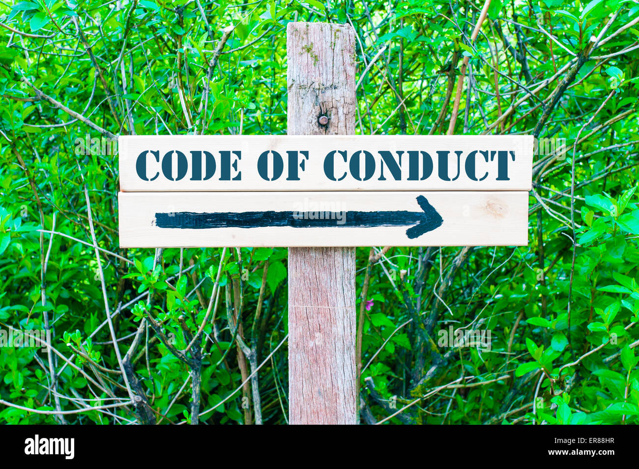 CODE OF CONDUCT written on Directional wooden sign with arrow pointing ...