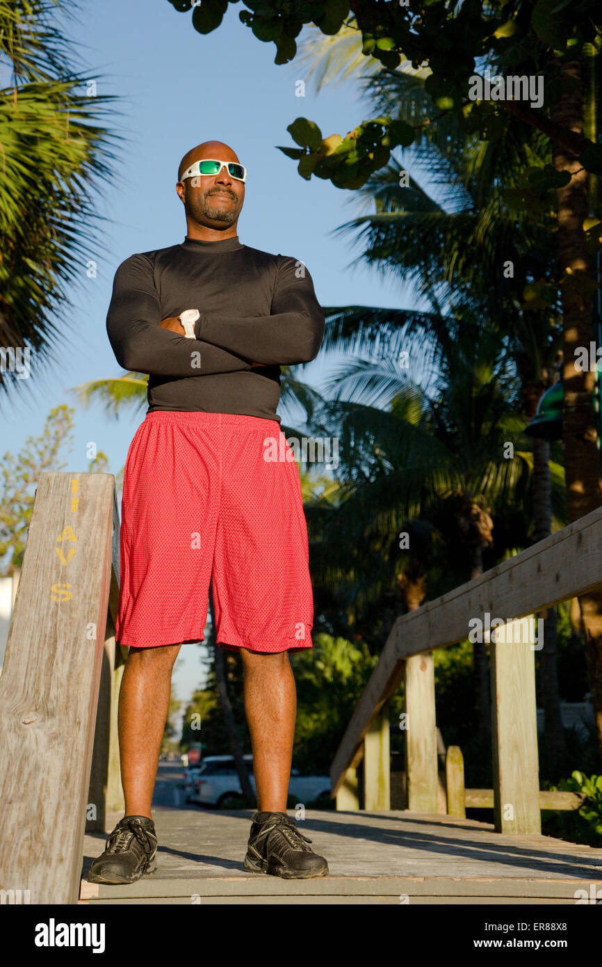 Athletic man standing on a boardwalk Stock Photo - Alamy