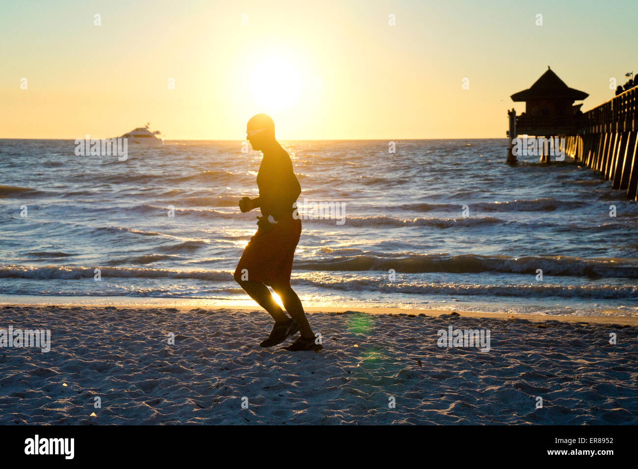 Man jogging on the beach at sunset Stock Photo - Alamy