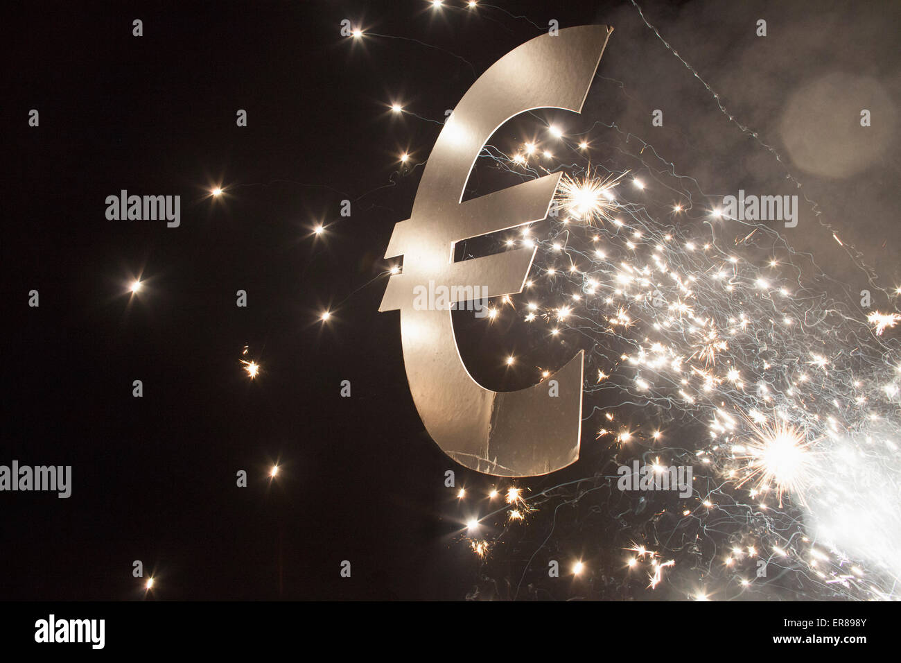 Illuminated euro symbol with fireworks at night Stock Photo - Alamy