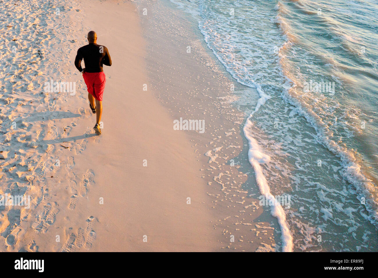 Man running on the beach Stock Photo - Alamy