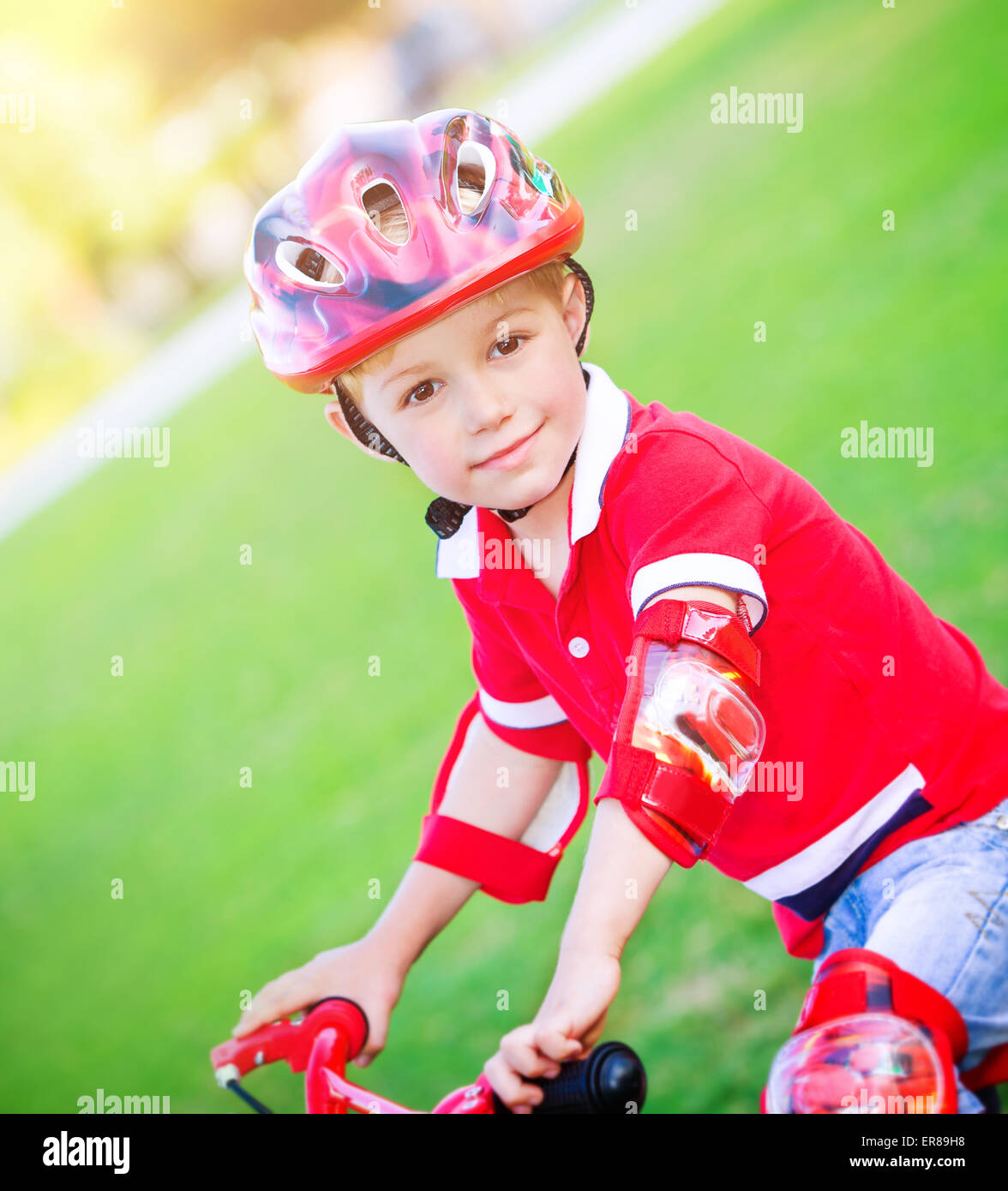 Little boy on bicycle wearing red protective helmet, having fun on ...